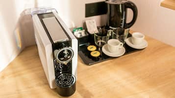 Uma máquina de café com uma bandeja de xícaras e uma jarra sobre uma mesa de madeira.