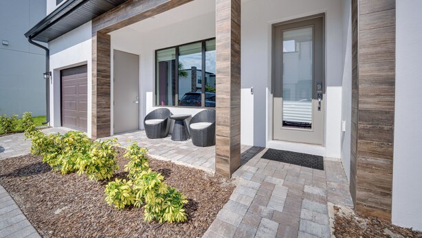 Uma casa moderna com varanda coberta, área de estar externa e garagem.