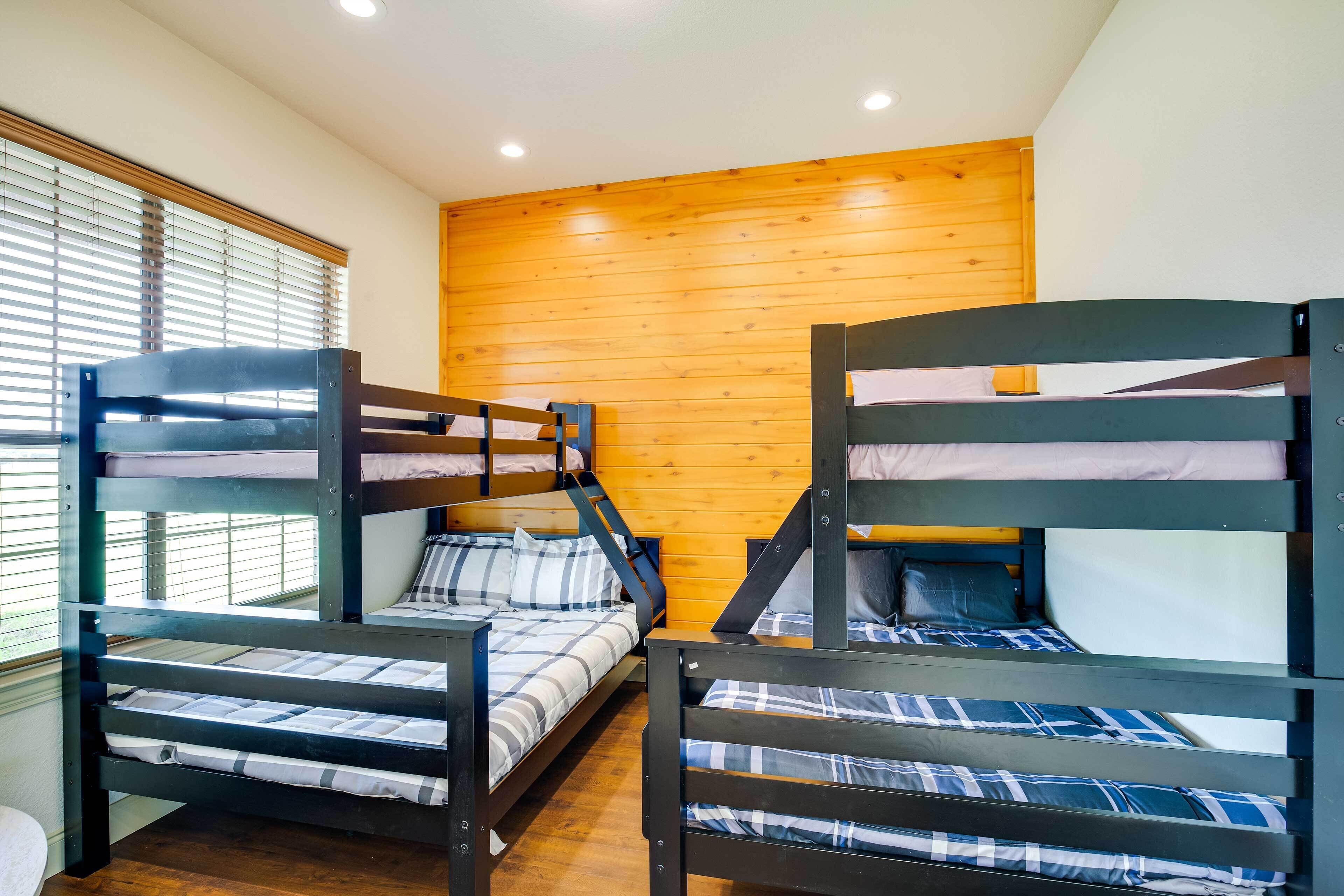 Quarto com beliches, paredes de madeira e janela com persianas.