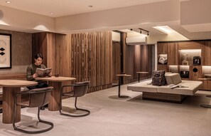 Uma área de estar moderna com painéis de madeira, um sofá e uma mesa com cadeiras.
