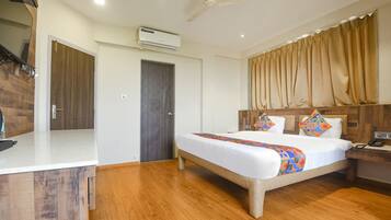 Quarto de hotel com cama, mesa de cabeceira e ar condicionado.