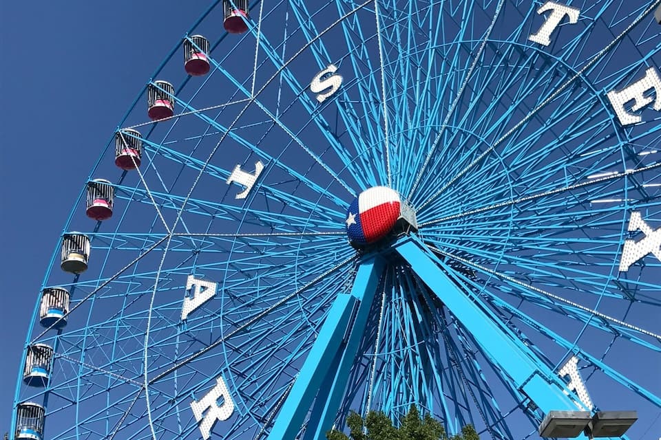 Uma grande roda gigante com cores azul e branca, com letras.
