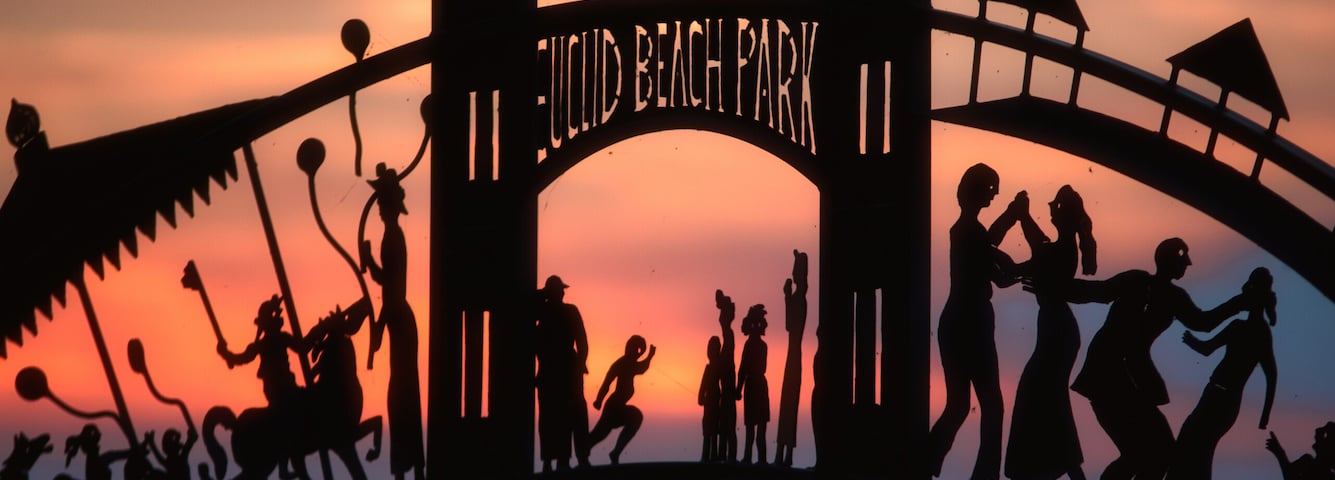 Silhueta de uma entrada de parque com o nome 'JULIUS BEACH PARK' e um poste de luz.