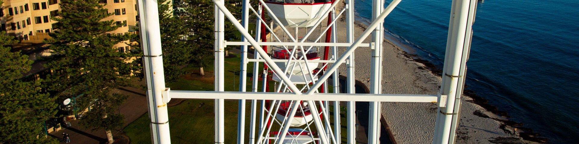 Uma área costeira com uma torre de observação alta, uma praia e um edifício grande ao fundo.