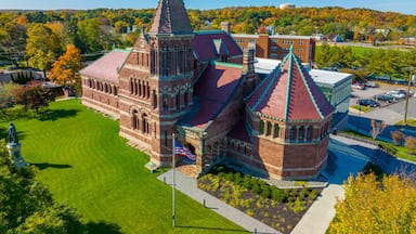 Um grande edifício de tijolos com telhado pontiagudo e um mastro com a bandeira americana.