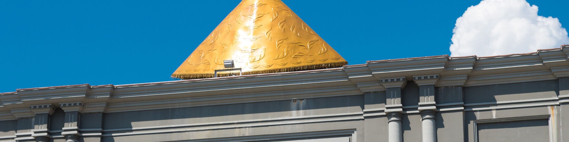 Uma cúpula dourada com um emblema circular no topo, e uma placa abaixo com a inscrição 'PORTA MARIAE'.