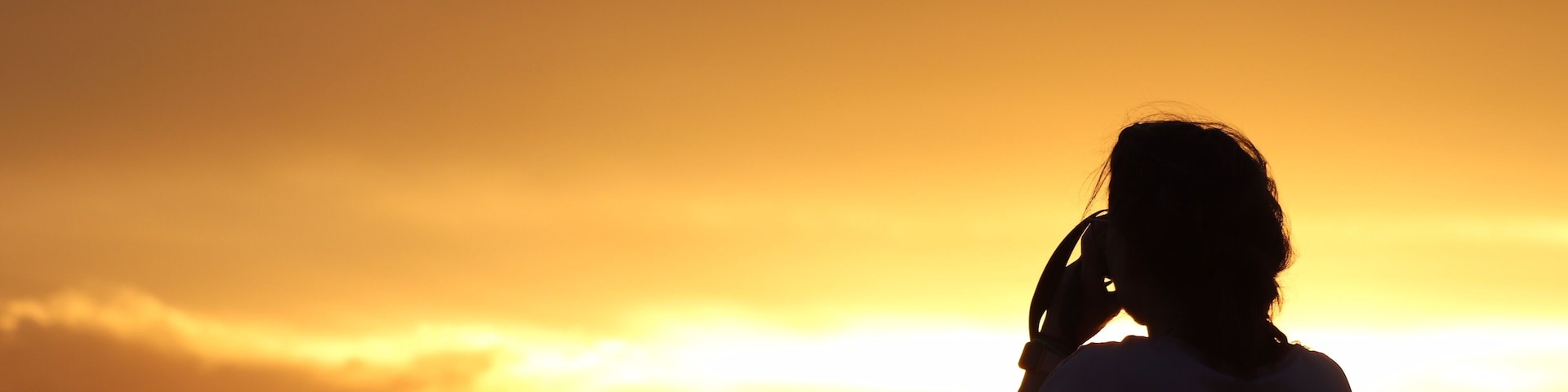 Silhueta de uma pessoa contra um céu ao pôr do sol.