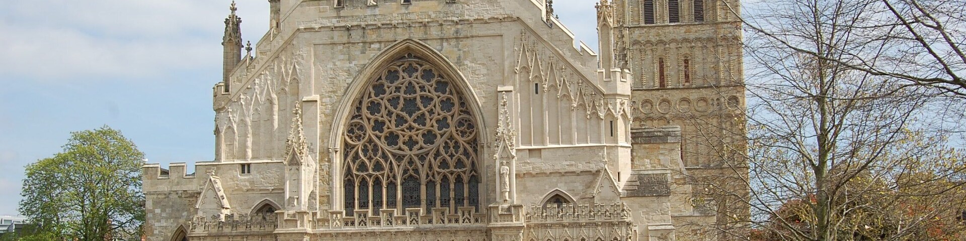 Uma grande catedral em estilo gótico, com detalhadas esculturas em pedra e uma rosácea imponente.