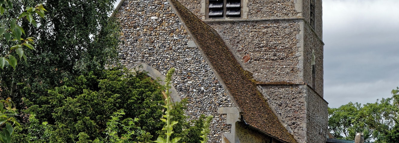 The north-east of the Grade I listed 11th- to 15th-century Parish Church of St Andrew's, from the churchyard north brick wall, with holyhock Alcea rosea and ivy, in Boreham village, Essex, England. Camera: Canon EOS 6D with Canon EF 24-105mm F4L IS USM lens. Software: RAW file lens-corrected, optimized and converted with DxO OpticsPro 11 Elite, and further optimized with Adobe Photoshop CS2.
