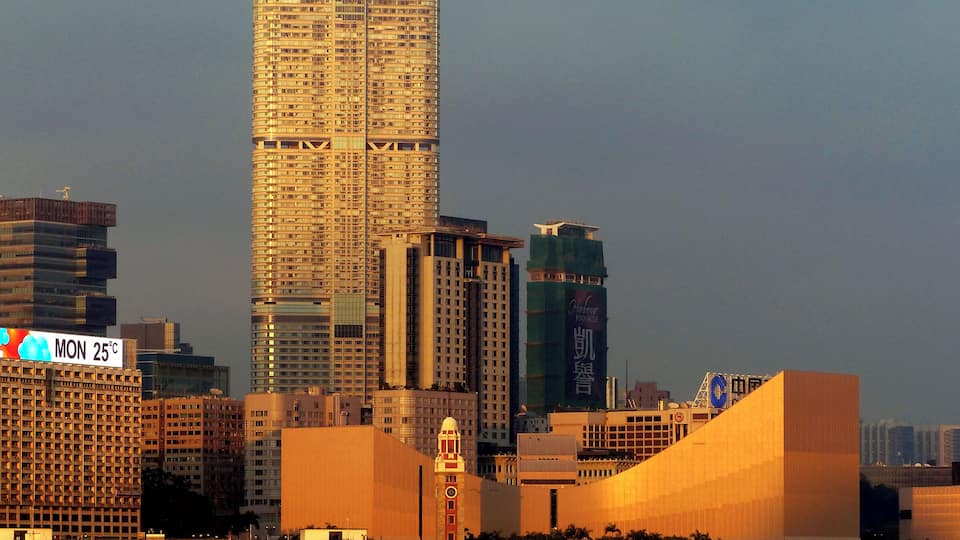 Silhueta urbana com edifícios altos, incluindo um arranha-céu imponente e um prédio moderno com design singular.
