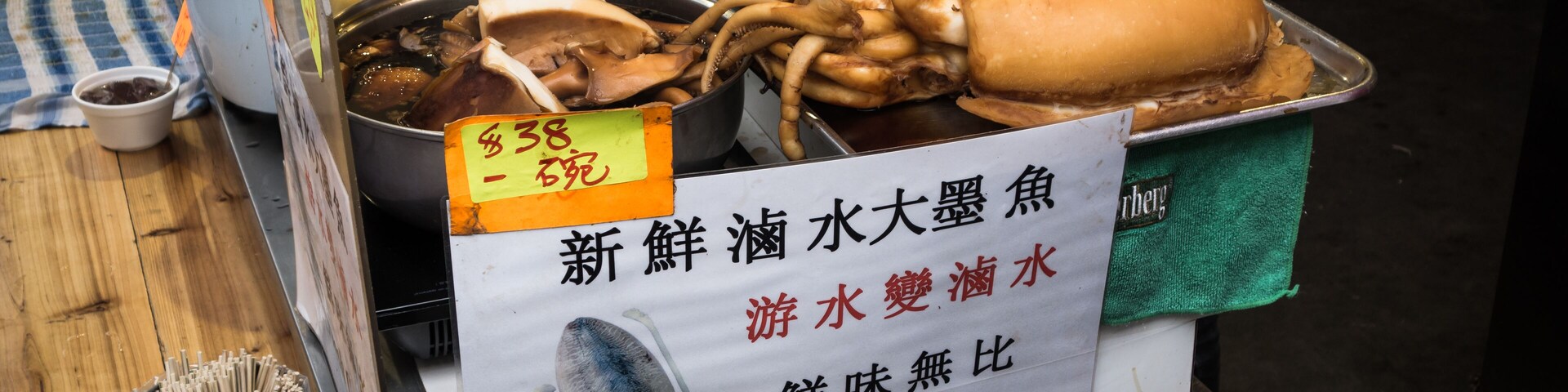 Banca de frutos do mar com um caranguejo grande e uma placa em chinês.