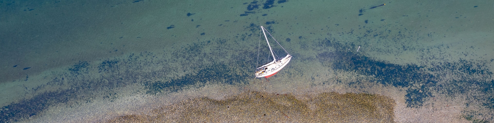 Um barco numa praia com água cristalina e areal arenoso.