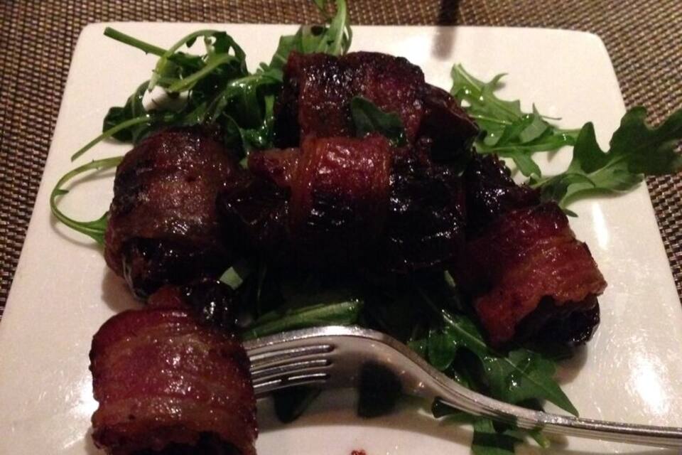 Prato de comida com carne e vegetais sobre uma mesa.