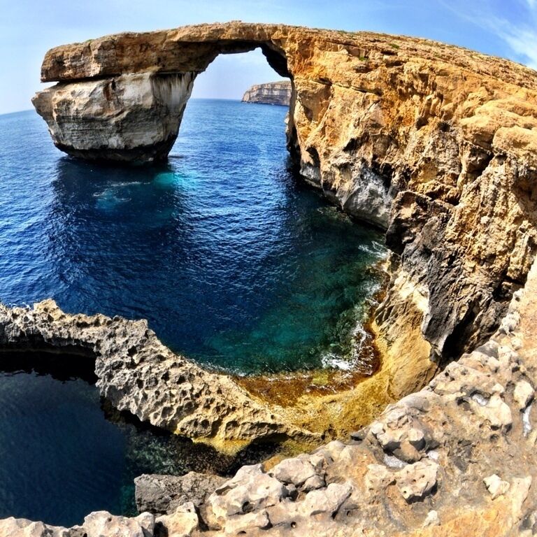 Formação rochosa natural com um grande arco sobre o mar.