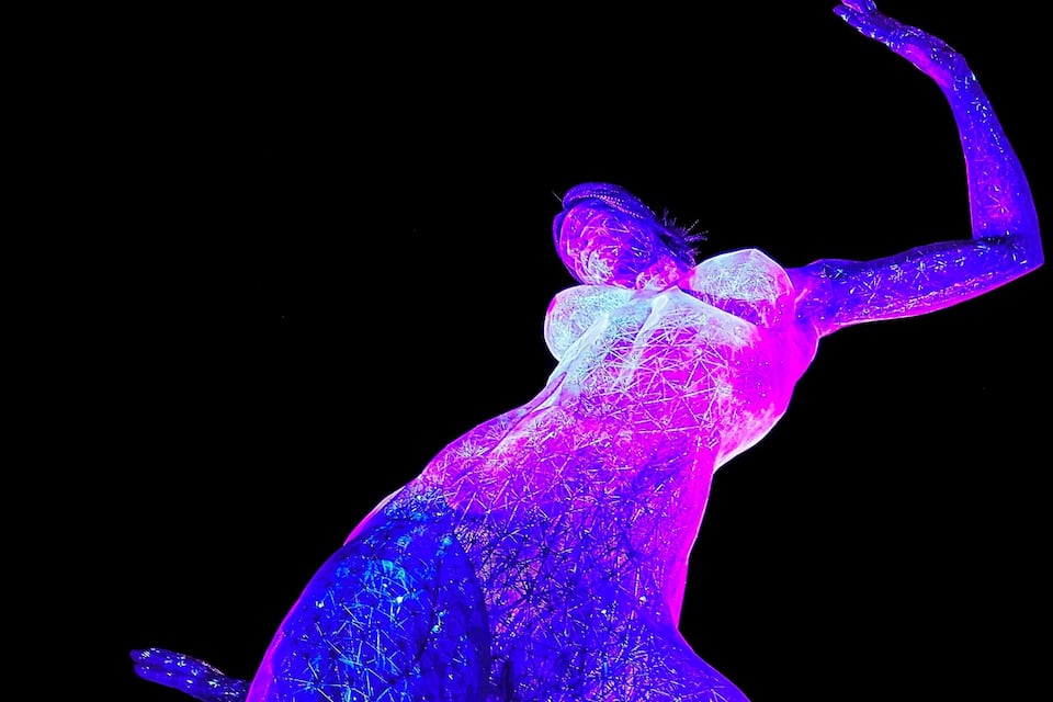 Uma pessoa iluminada por luzes azul e rosa.