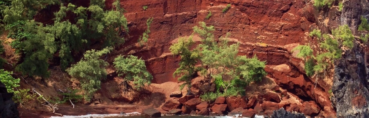 On the back side of Ka'uiki Hill in Hana, Red Sand (Kaihalulu) Beach is just a five minute hike, but steep drop offs and loose gravel from this cinder cone make it a treacherous trip. Not for the faint of heart or perpetually clumsy, but daring adventurers are rewarded with dramatic red cliffs and a cerulean blue cove providing a sheltered swimming area.