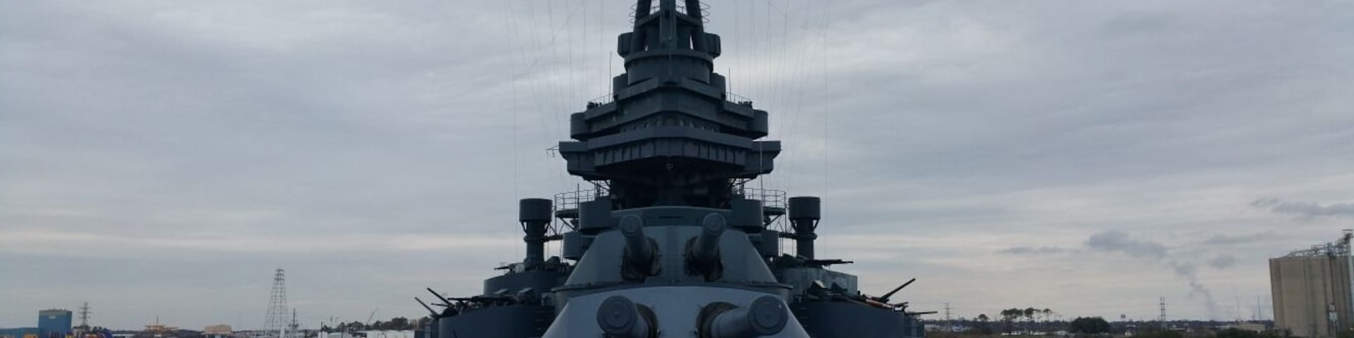 Um grande navio de guerra atracado em um porto sob um céu claro.