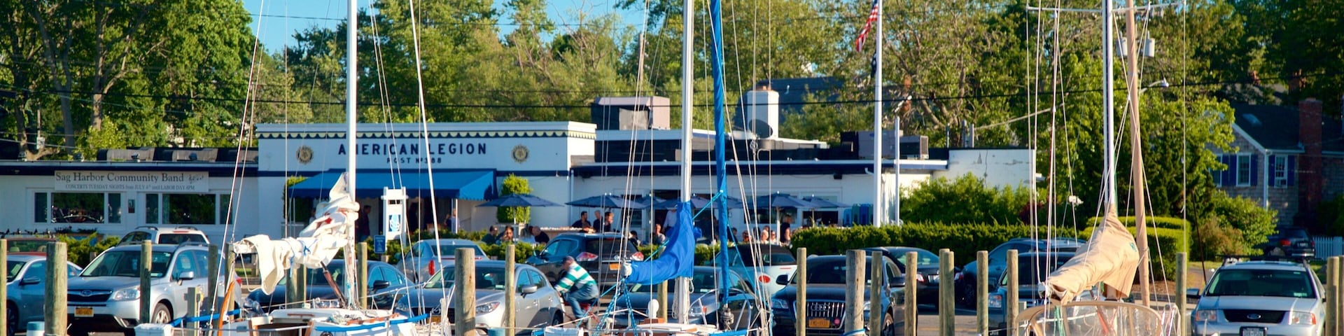 Uma marina com vários barcos atracados, um palco para banda e um restaurante chamado American Legion.