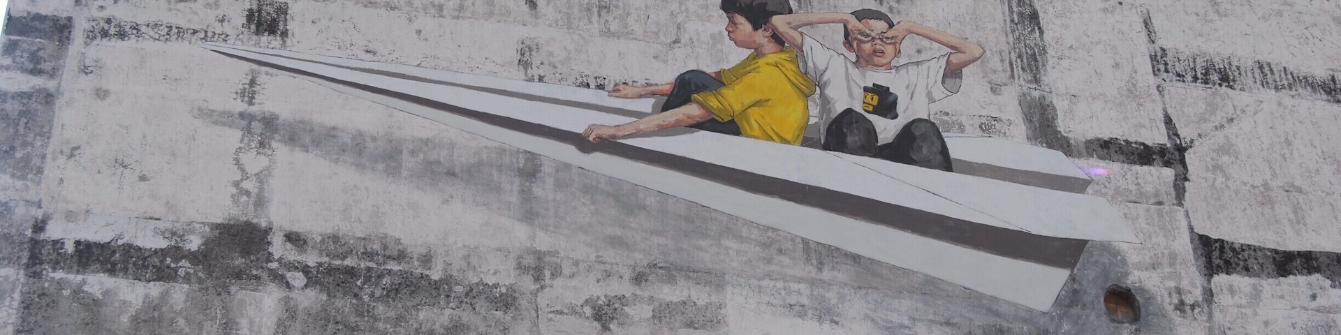 Um mural em parede de concreto com duas crianças.