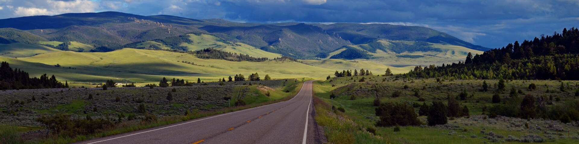 Uma estrada rural com céu limpo e montanhas ao longe.