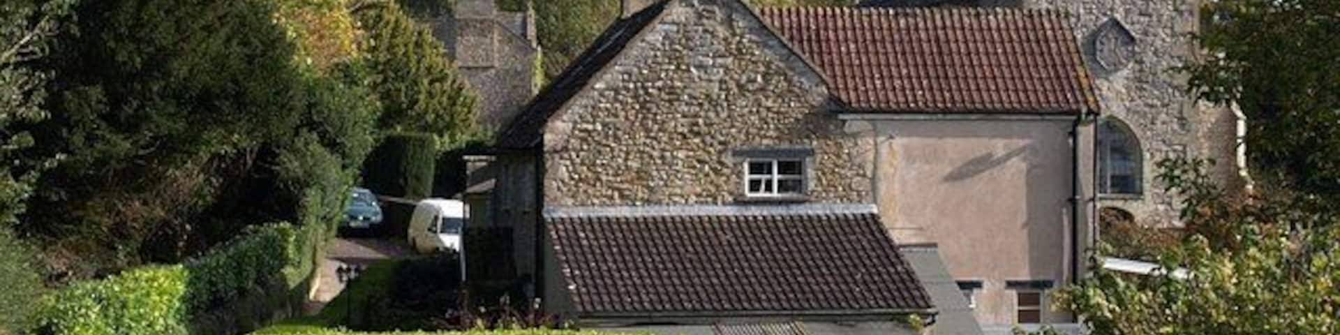 Approaching East Pennard church. The footpath from Home Farm approaches a cottage and the west end of the churchyard of 65801.