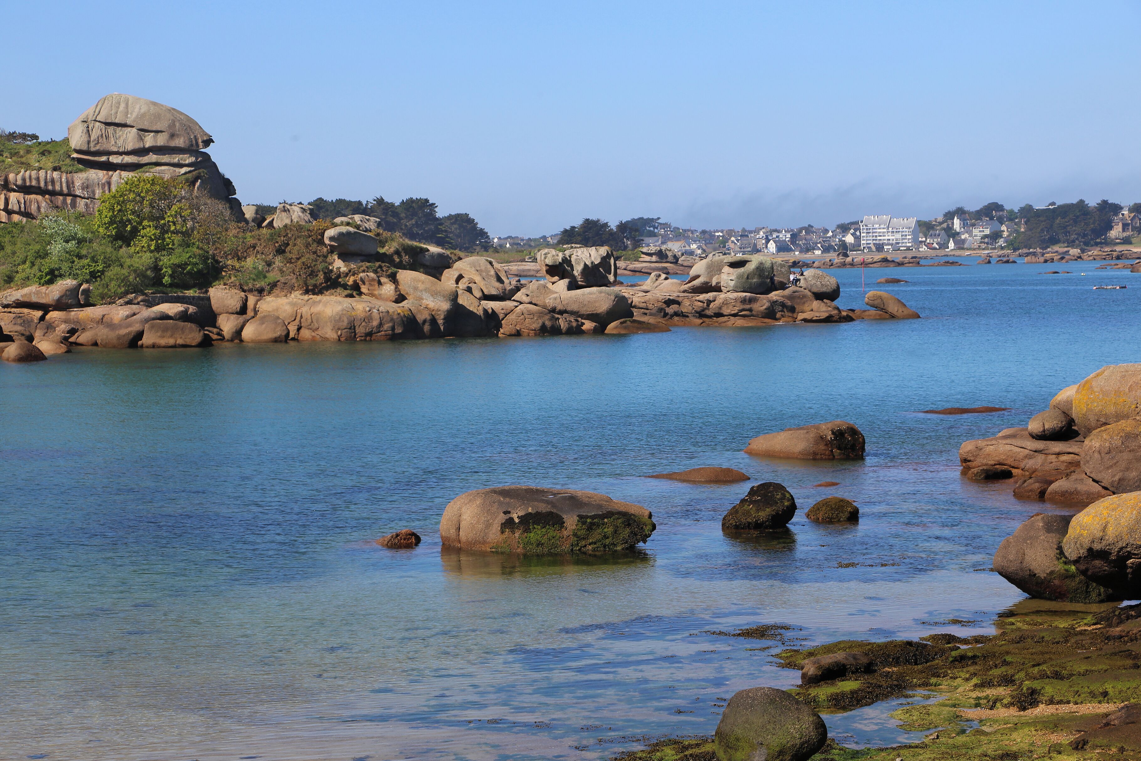 Paisagem costeira com grandes pedras e mar calmo.