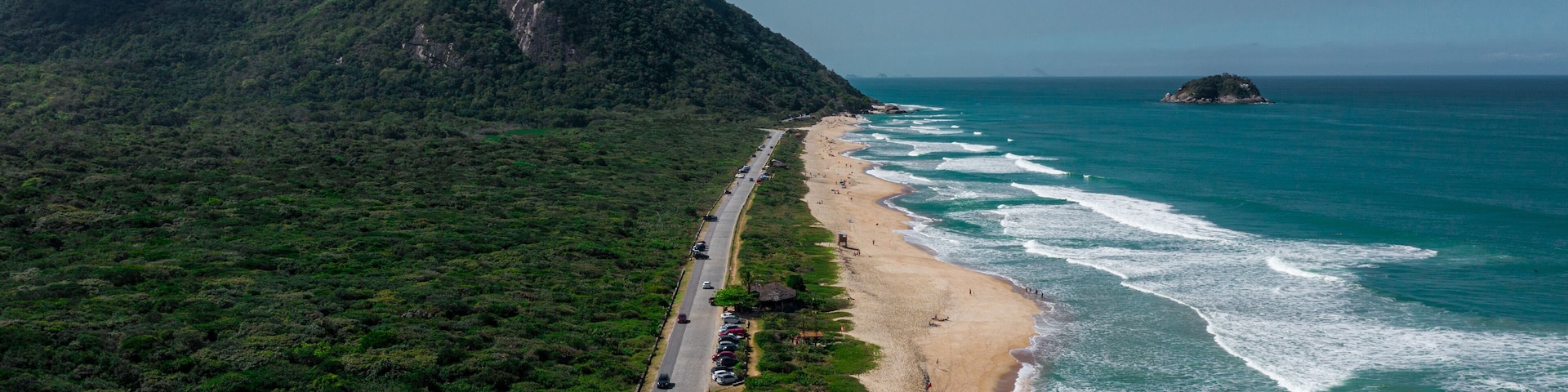 Uma estrada costeira com praia e montanhas.