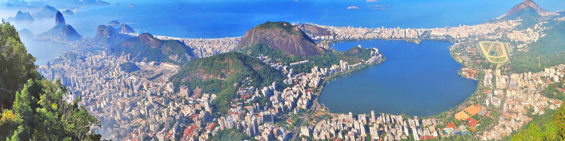 Uma vista panorâmica do Rio de Janeiro, com a estátua do Cristo Redentor, o Pão de Açúcar e a Baía de Guanabara.