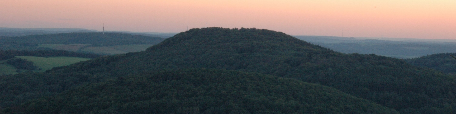 Das Bild zeigt die Nordost-Seite des Weiselbergs. Es wurde aufgenommen vom Aussichtspunkt des nahe gelegenen Freisener Steinbruchs, einem Geheimtipp unter Spaziergängern und Wanderern. Von dieser Seite betrachtet, kommt die Kegelform des inaktiven Vulkans deutlich zur Geltung. Der Weiselberg und das gleichnamige Naturschutzgebiet beherbergen seltene Pflanzen. Die Natur kann auf verschiedenen Rundwegen zwischen 4 und 18 Kilometer Länge erkundet werden.