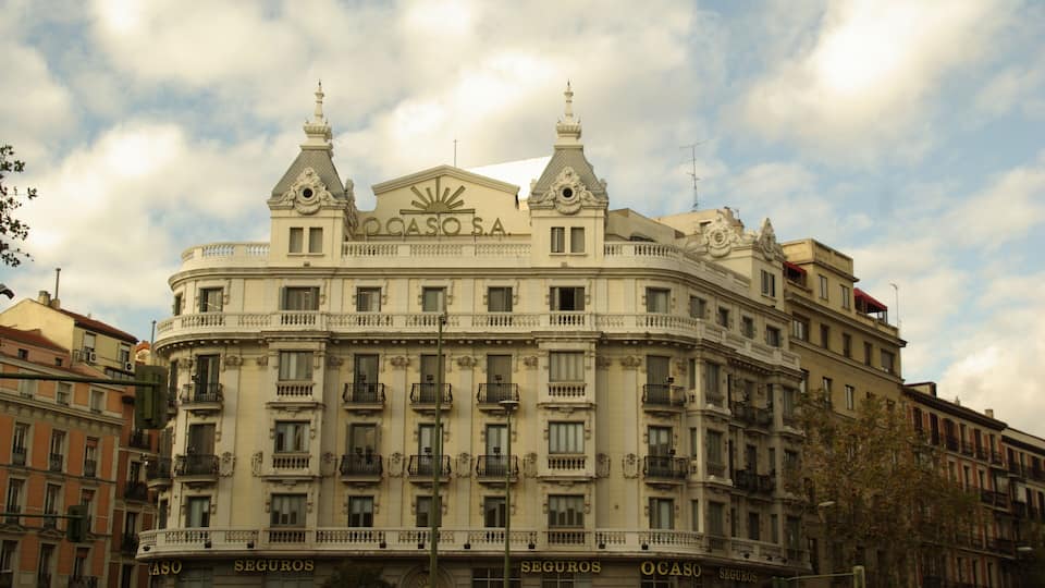 Um edifício histórico com varandas ornamentadas e uma placa de destaque com a inscrição