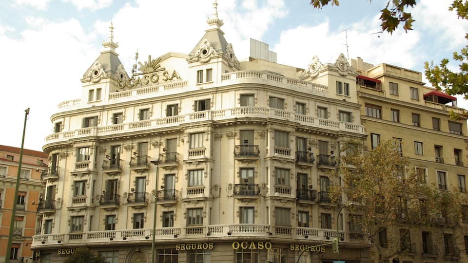 Um edifício histórico com varandas ricamente decoradas e uma placa com a inscrição "SEGUROS OCASO".