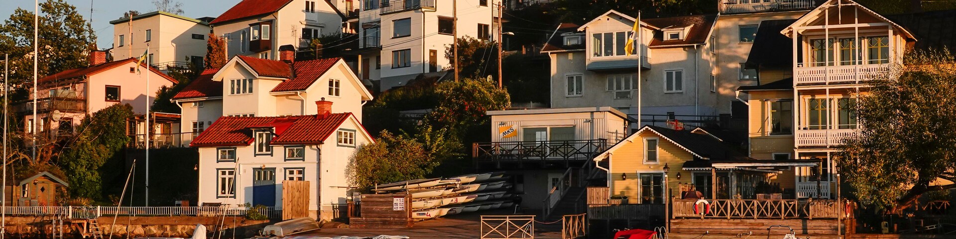 Margem com casas, barcos e um cais.