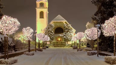 Igreja coberta de neve com uma torre alta e um edifício menor na frente.