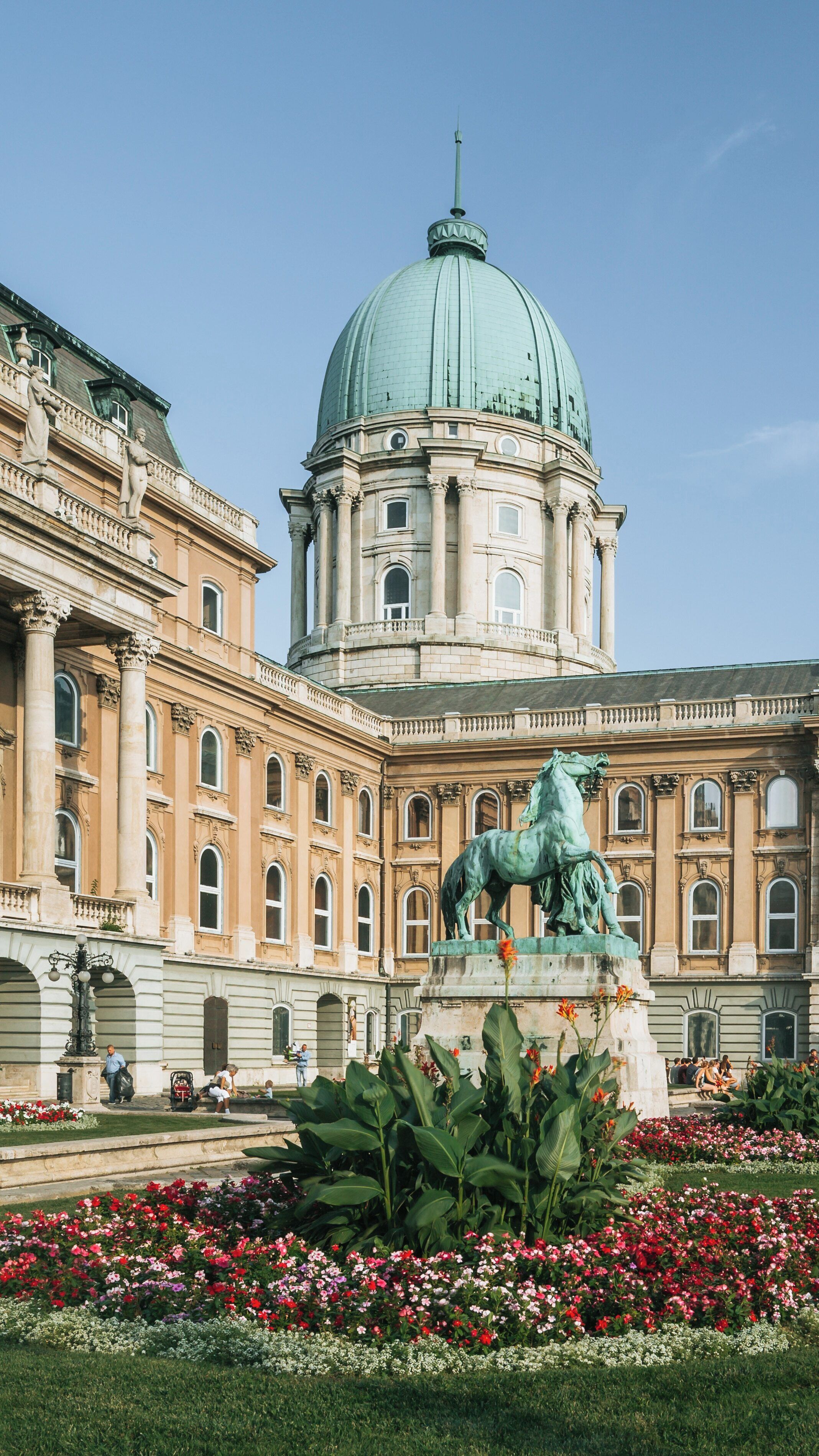 Buda Castle showcases its stunning architecture and vibrant gardens in Budapest City Centre, Hungary under a clear blue sky