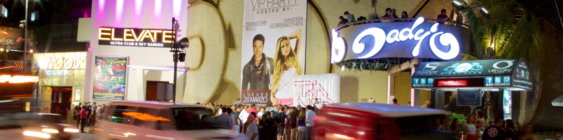 Rua movimentada com um grande outdoor anunciando uma festa VIP.