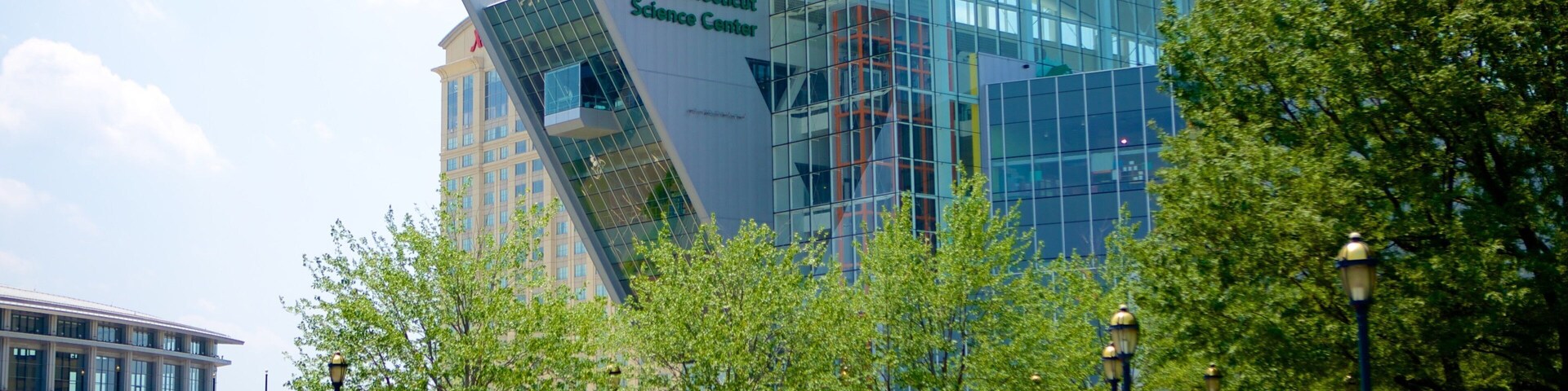 Centro de Ciências de Connecticut, um edifício moderno em vidro, rodeado por vegetação.