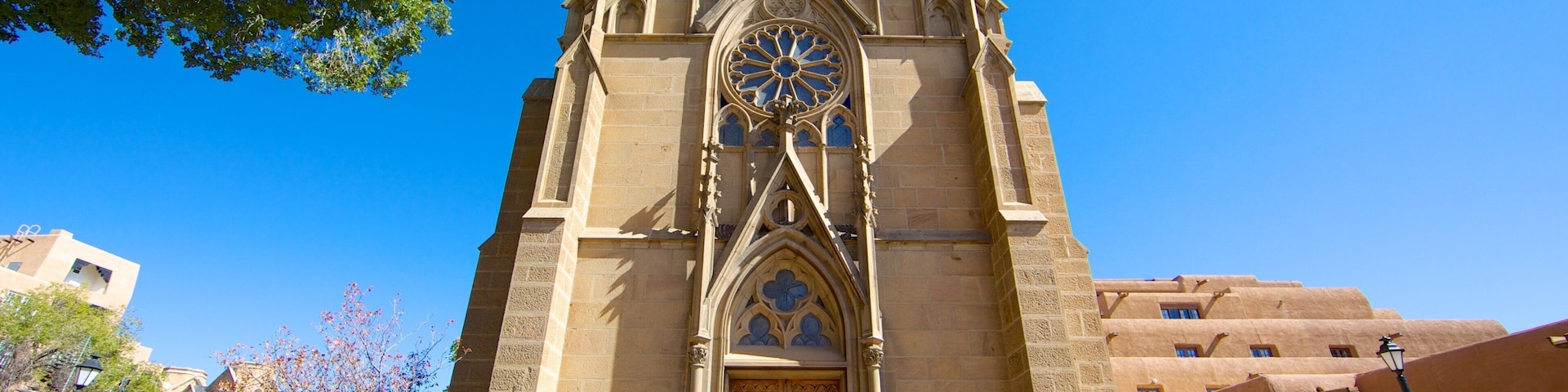 Uma igreja em estilo gótico, com um rosário grande e uma estátua no topo.