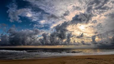 Uma praia com ondas e céu nublado.
