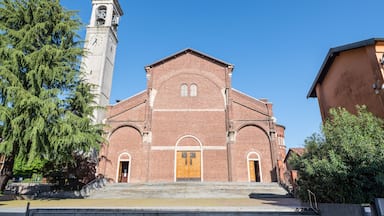 Uma igreja histórica com uma torre de sino e uma grande porta de madeira.
