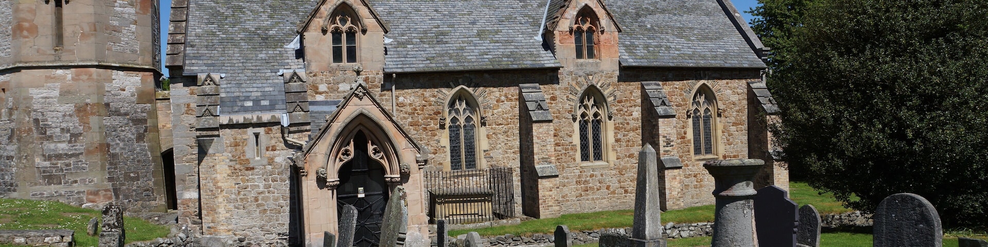 Nave and base of the west tower of parish church of St Michael the Archangel, Llanyblodwel, Shropshire, England. The sundial in the foreground was made in 1712.