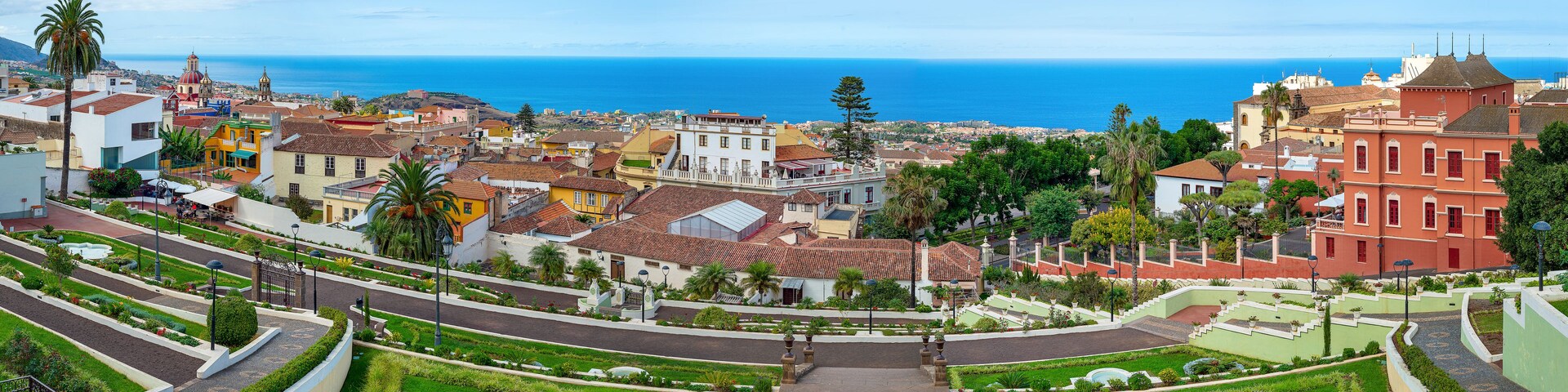 Uma vila costeira com edifícios coloridos, uma igreja e vista para o mar.