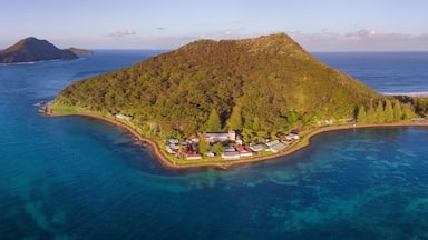 Uma ilha com floresta densa, um pequeno povoado e águas azul-claras.