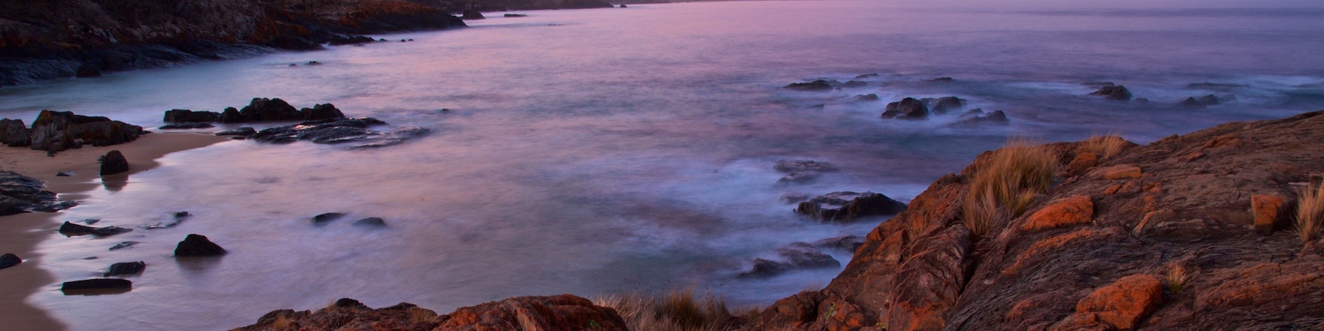 Swansea which includes rugged coastline, general coastal views and a sunset