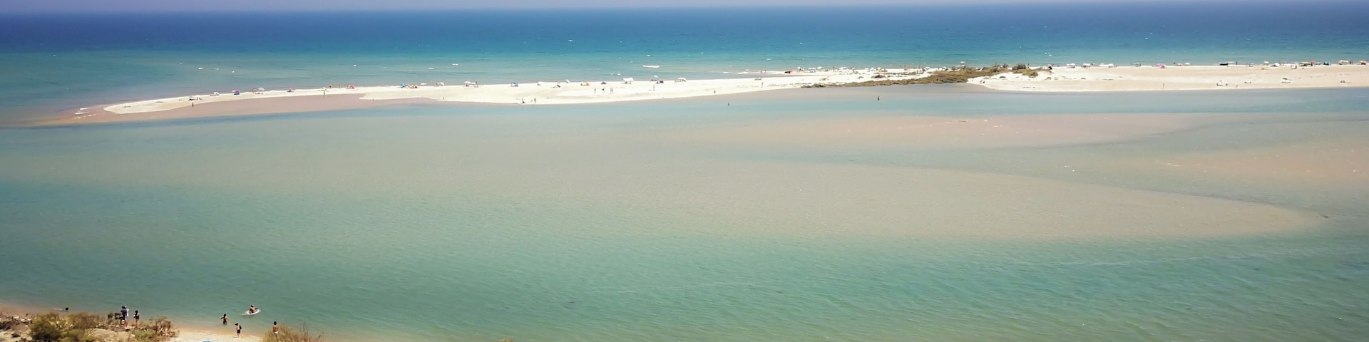 Almost like a watercolor painting, the view of the Ocean from the very small village of Cacela Velha in Portugal is enchanting and beautiful. During some hours is possible to cross to the landline walking, other times a boat is needed to get there.