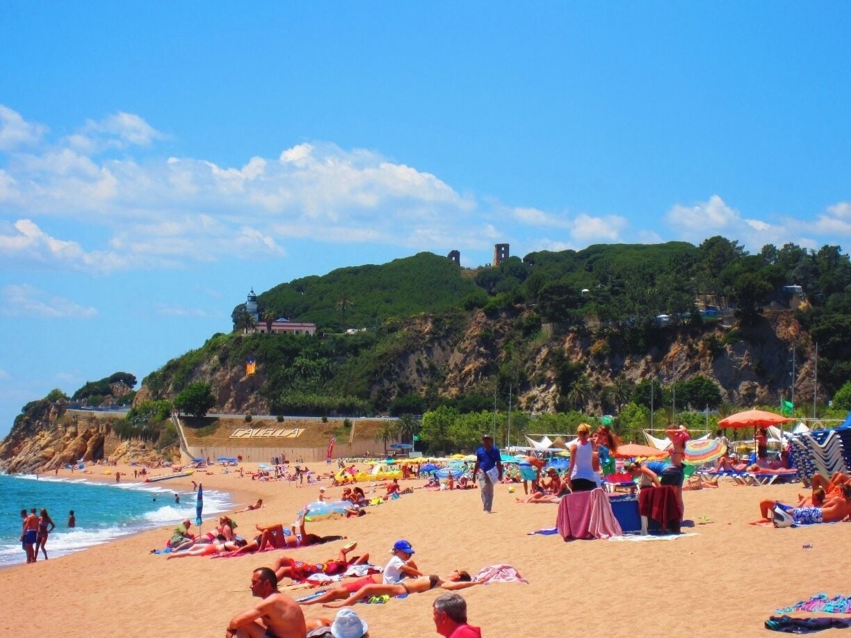 Beautiful clean white sand for miles and crystal clear turquoise water. Parties & bars on the beach, some free concerts in the summer time. You can hike up into the hill here, there are some old ruins up there, you can see peeking out from the trees in this photo. 
Apparently since the 70's, Calella, was a booming tourist destination for Western Europeans and the British. It has been on a massive decline over the past decade. What's left behind though are some fun Dutch and English/Irish pubs, a small welcoming expat community, and one of the most incredible beaches you will ever lay your eyes on. 
If you happen to find yourself here, you must stop in at Beach Boys Club, tell the owners, Brian & Cathy, that Amber sent you. Then hit up Brian for his secret stash of American imported Budweiser (Did you know the bottled stuff is always produced in country? Brian believes the secrets in the water, so he gets the cans from the US. Brian is British, which makes this little story even better.)
Also, be prepared to eat a lot of rotisserie chicken.