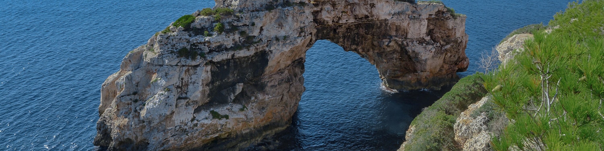 In front of the cliffs of Santaní (Mallorca) there is a natural stone arch called "Es Pontàs" - the bridge. The American rock climber Chris Sharma established a climbing route (9b) at the inside of the bow in 2006.