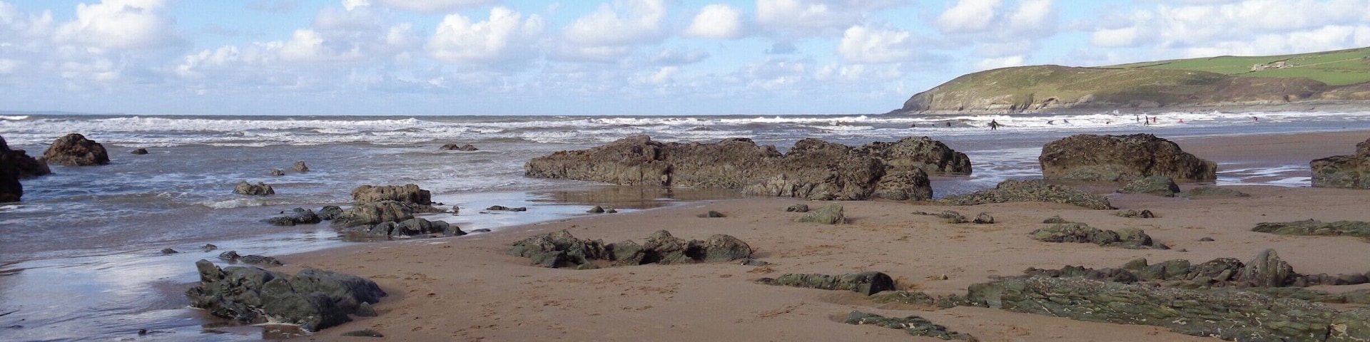 Extraordinary rock formations surrounding a vast sandy beach extremely popular with surfers.