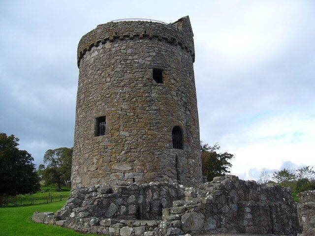 Uma torre de pedra com base circular e janelas em arco.