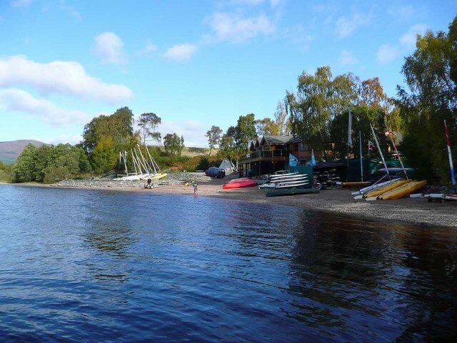 Um lago com barcos, um píer e um edifício.