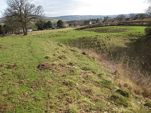 Earthworks, Dingestow During its construction in 1182, Dingestow Castle was attacked by the Welsh and is thought to have been abandoned as no stonework has been found. There are two enclosures surrounded by ditches and a stream on the western side. View is looking across the earthworks towards the village.
